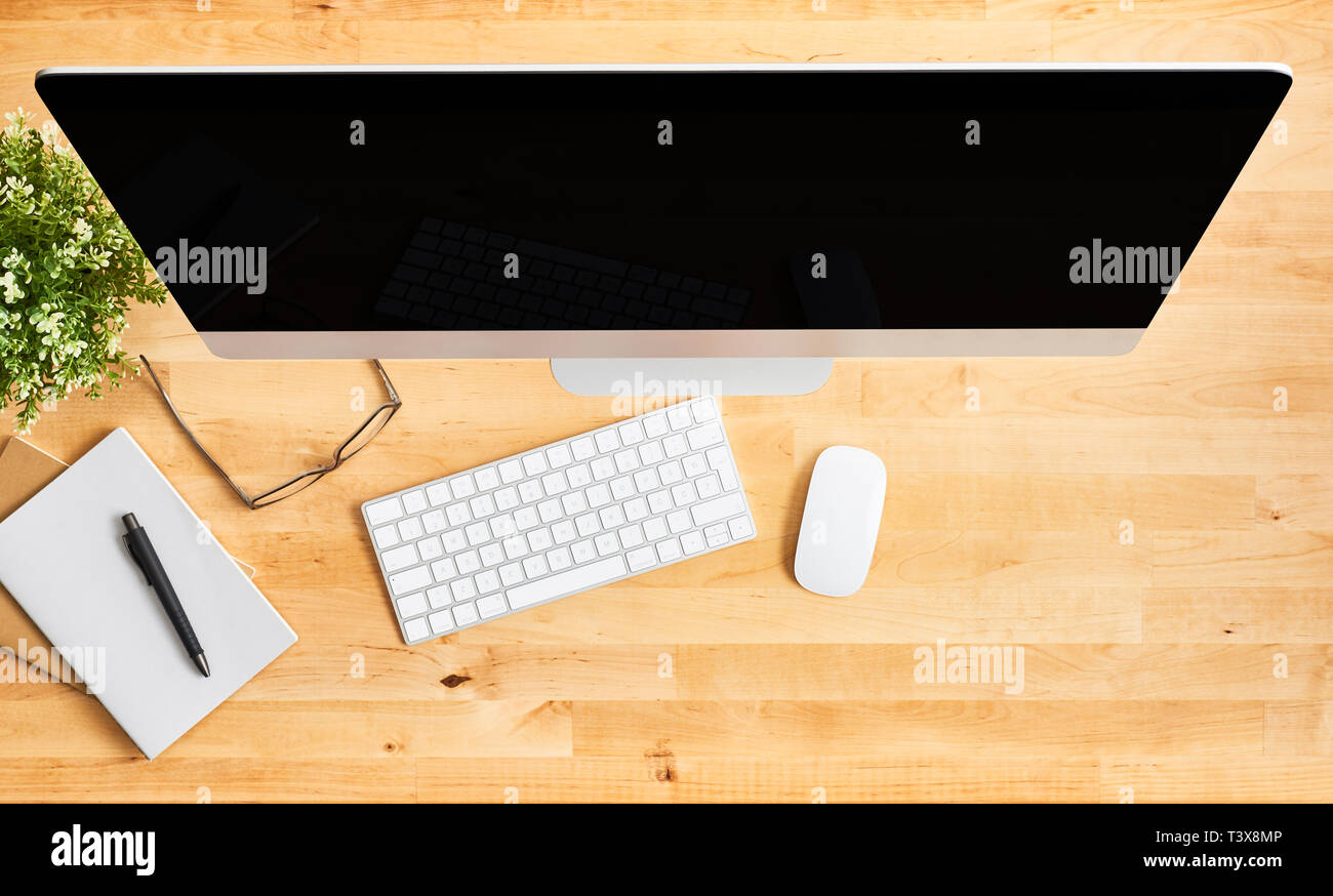 Modern desktop computer. Top view of wooden office desk with large ...