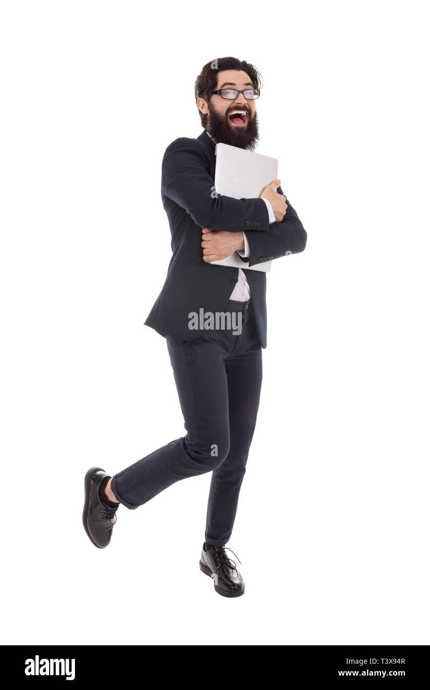 Full length studio portrait of a bearded businessman hugging laptop ...