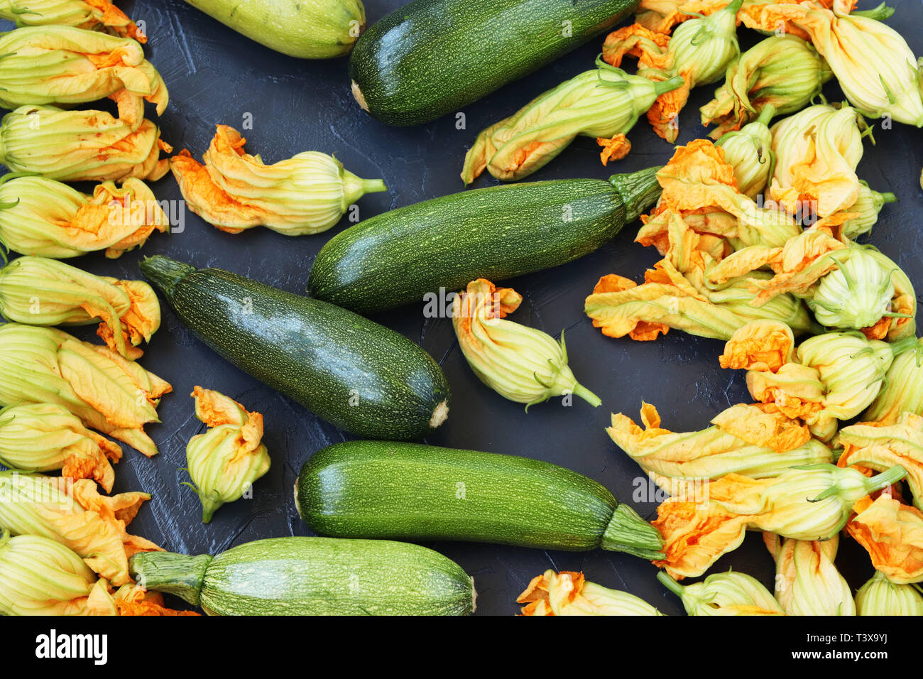 Vegetables and flowers of zucchini, located on a dark background ...