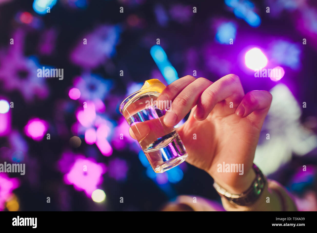 Hand holding a glass with vodka shot Stock Photo - Alamy