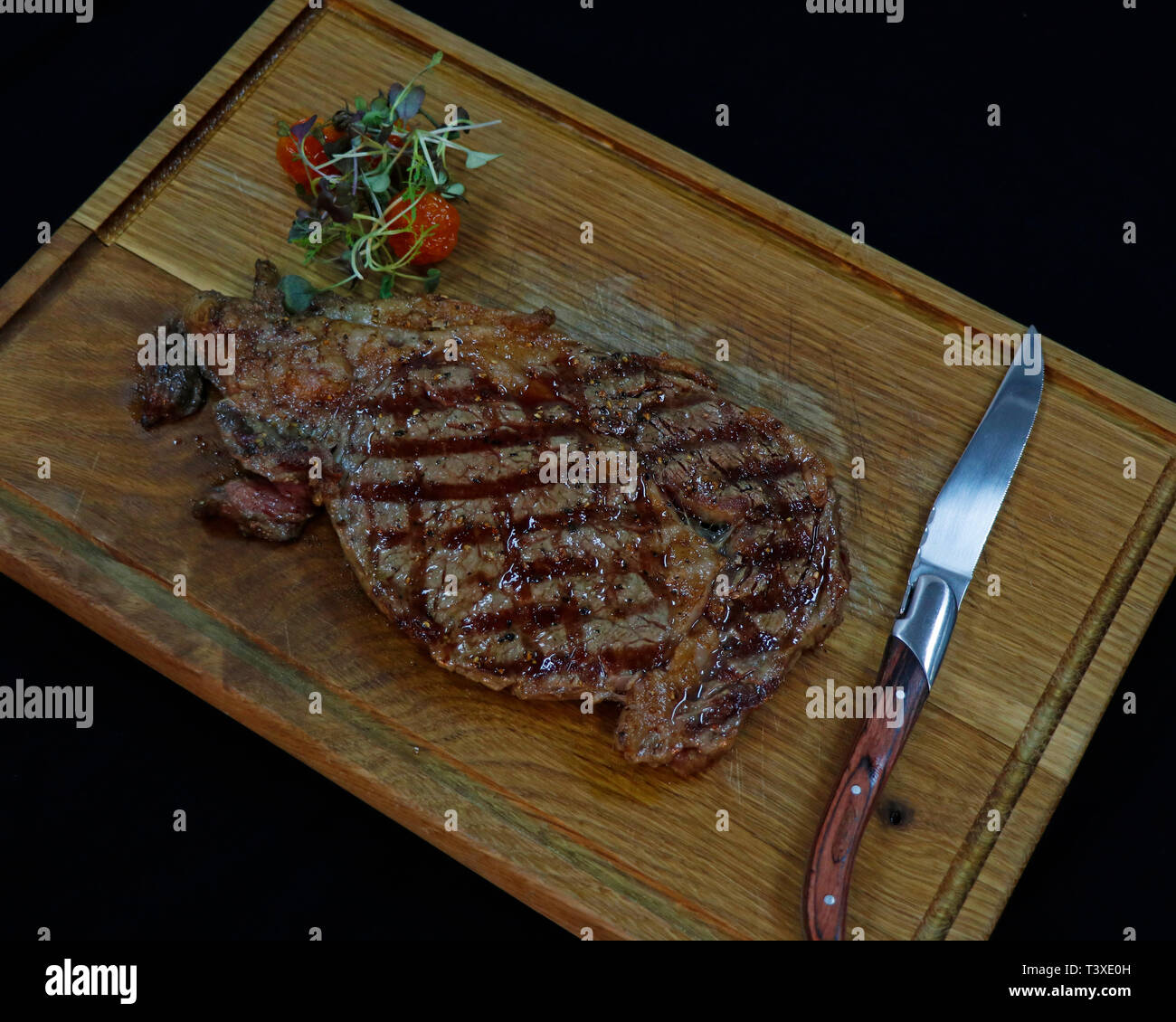 american Angus beef grilled rib eye steak on a wood board with knife ...