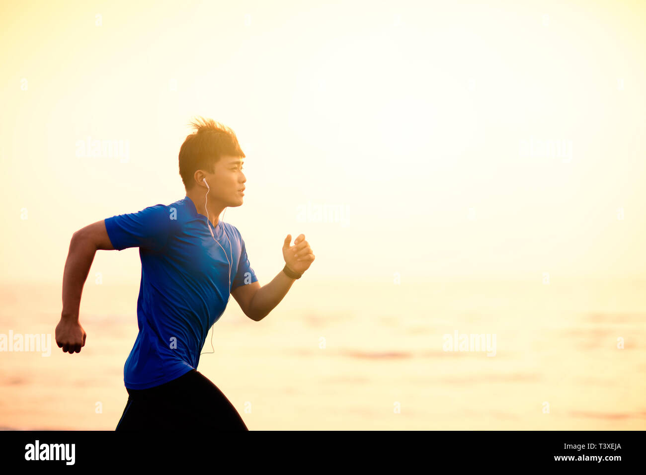 Man running on beach at sunset hi-res stock photography and images - Alamy