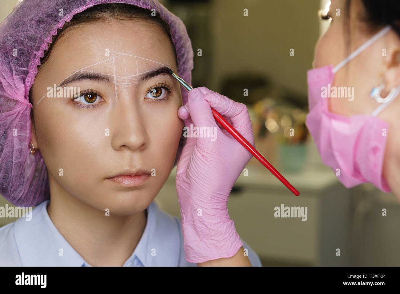 Microbleeding and eyebrow architecture. Cosmetologist applies coloring ...