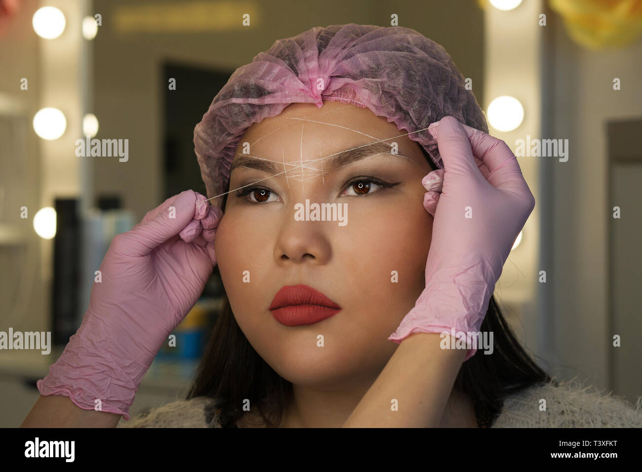 Microbleeding and eyebrow architecture. beautician builds lines of ...