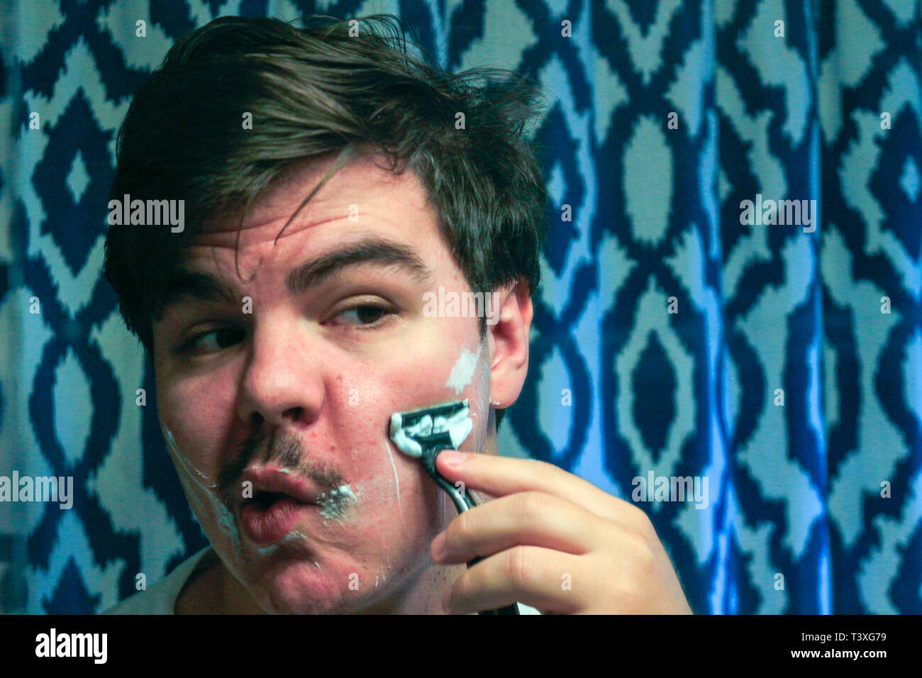 Serious guy shaving his beard Stock Photo - Alamy