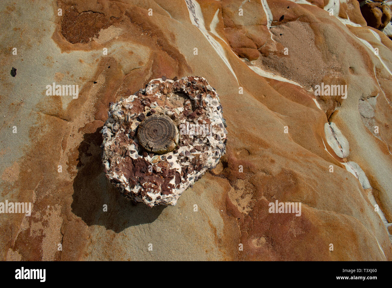 A cut off gate post and limestone rock outcrop with different bands of ...