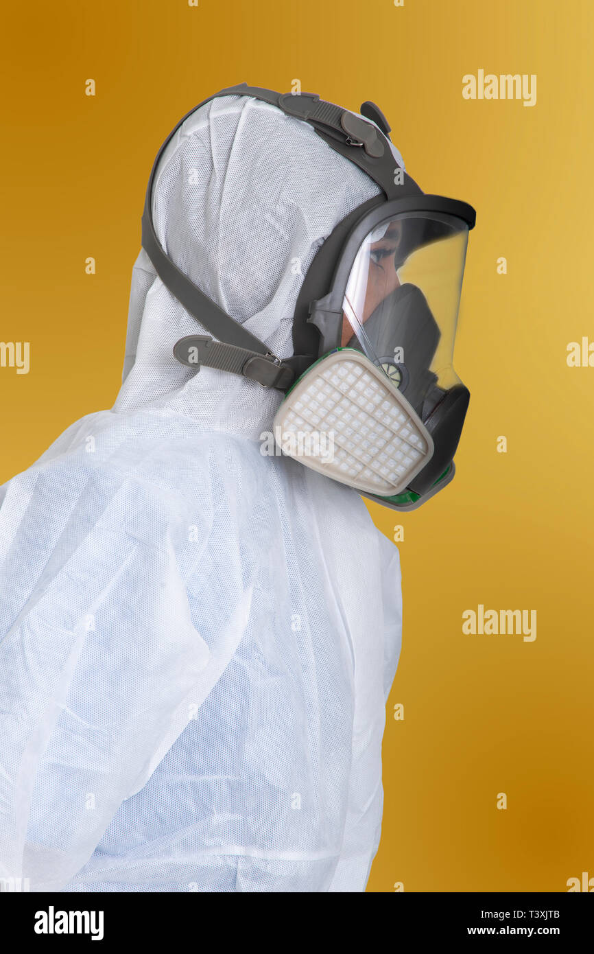 Side view of female worker in air pollution protection suit on yellow ...