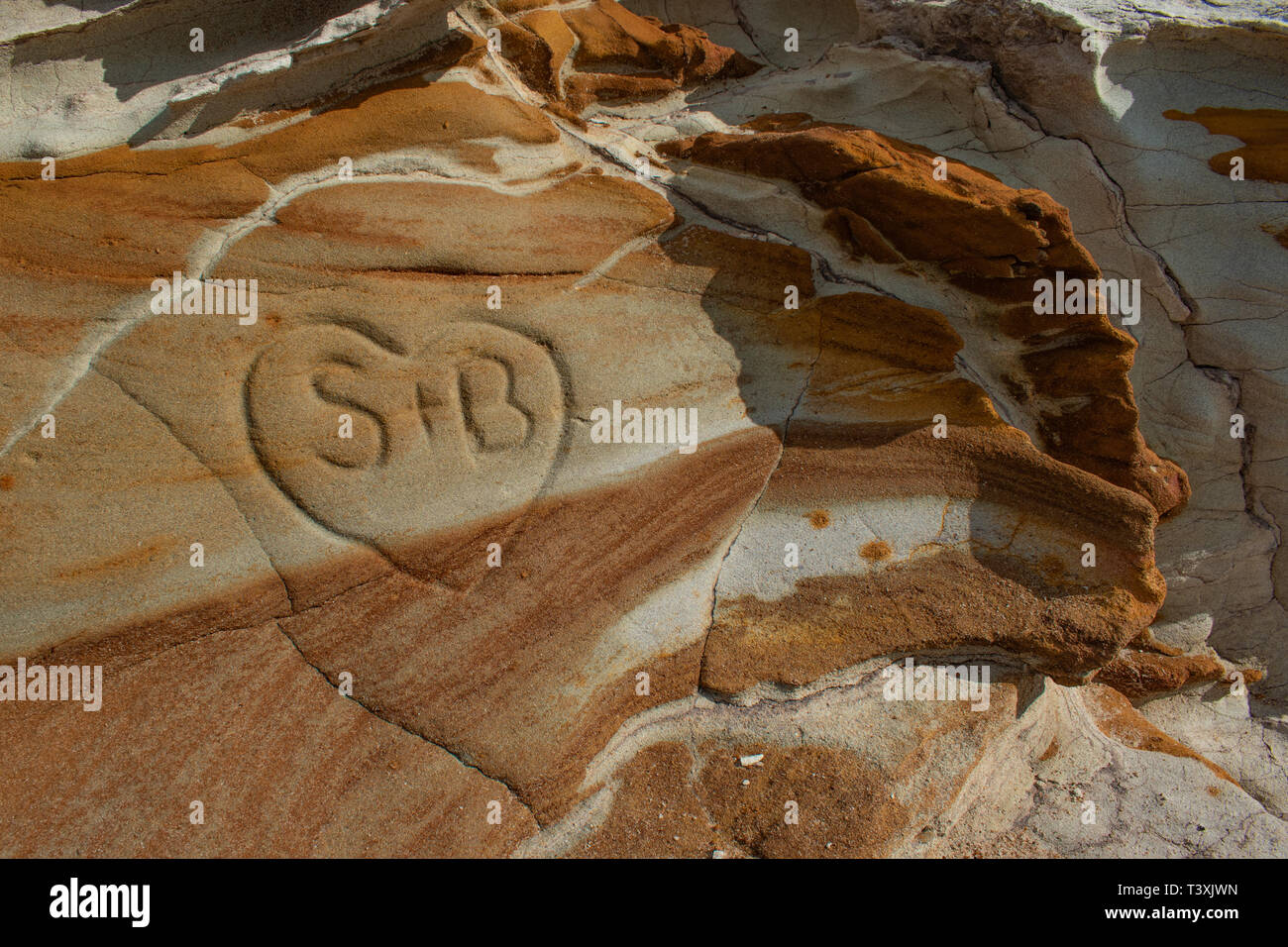 A heart carved into a limestone rock outcrop with different bands of ...