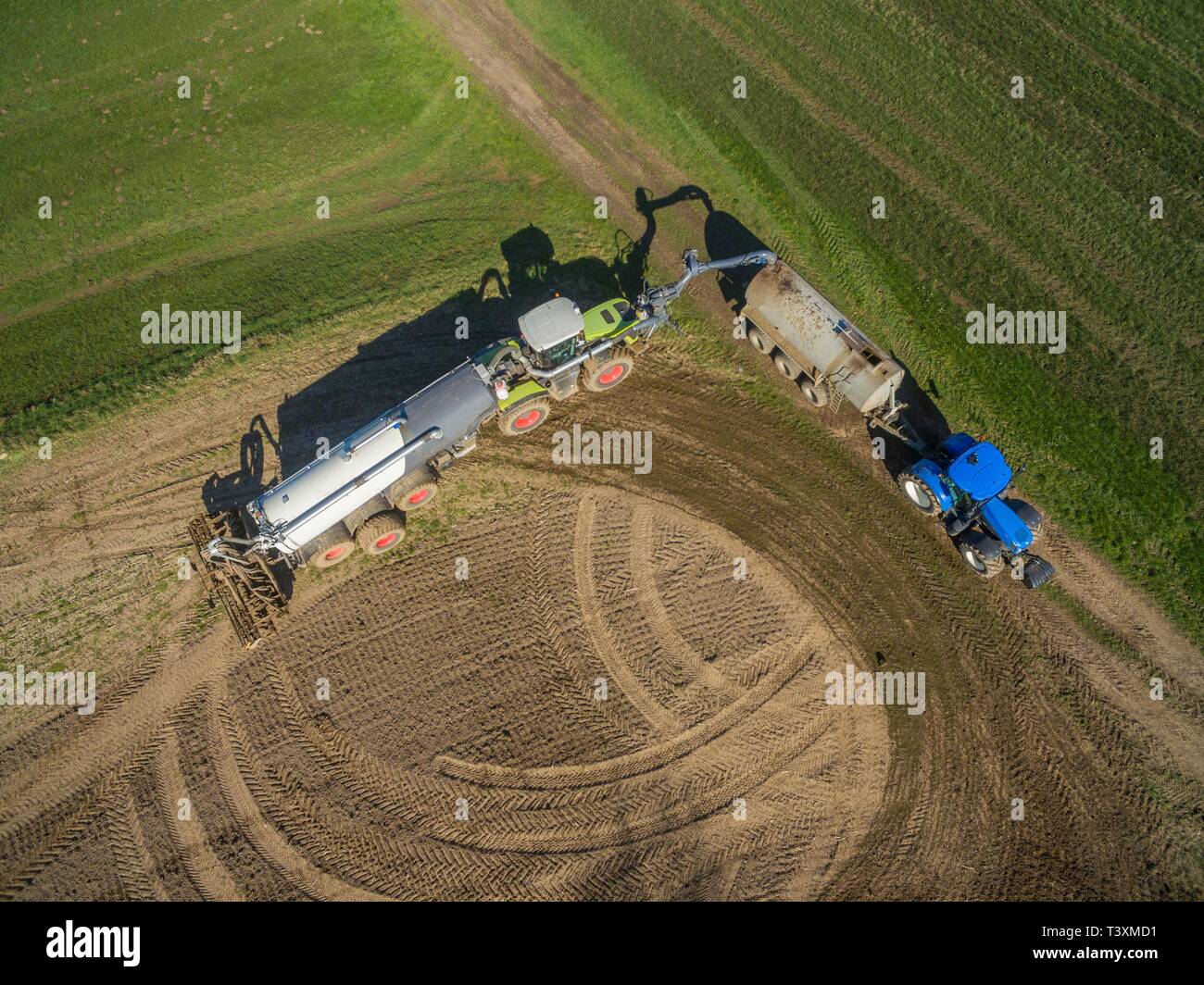 aerial view of a tractor with a modern fertilizer trailer and a second ...