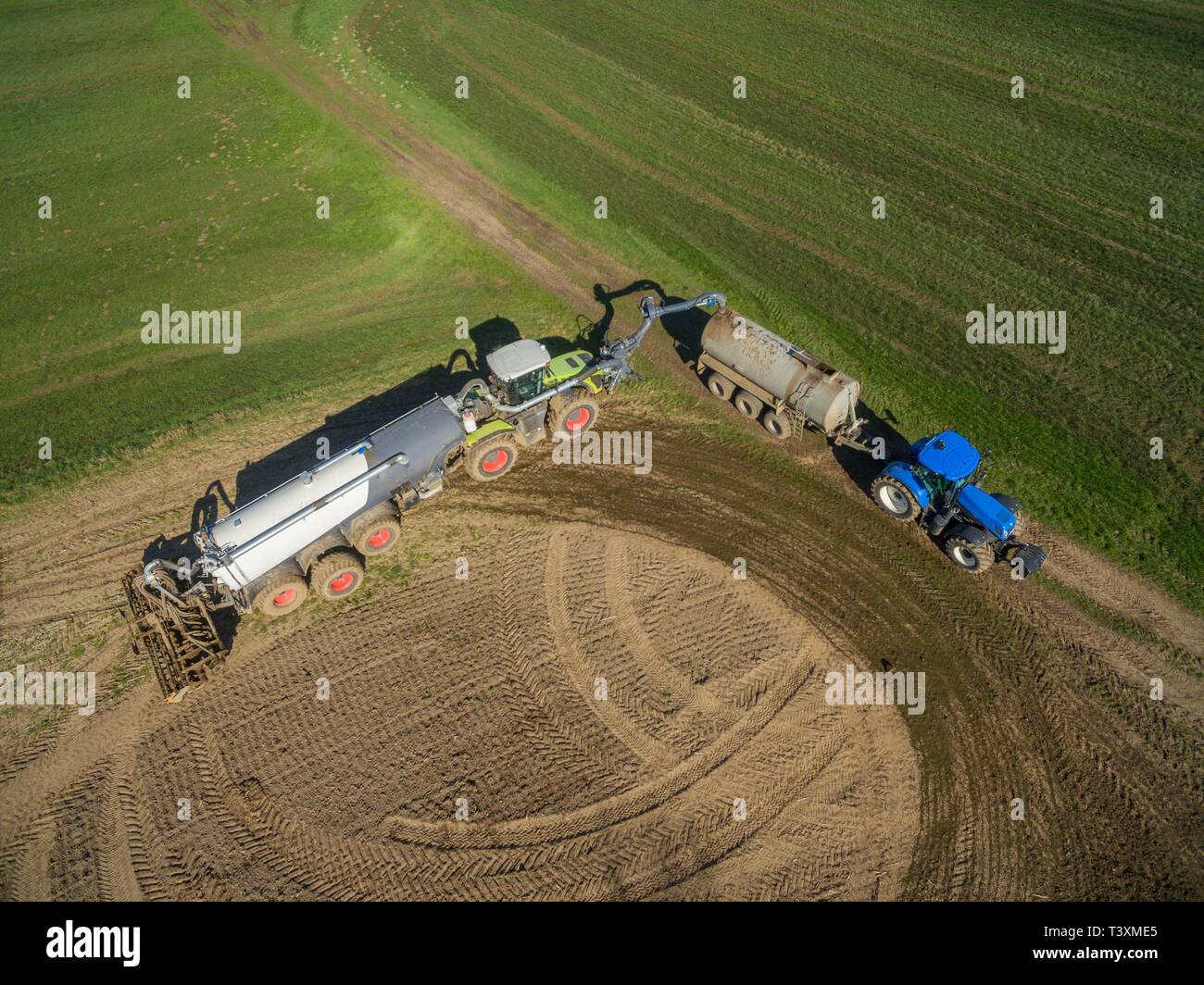 aerial view of a tractor with a modern fertilizer trailer and a second ...