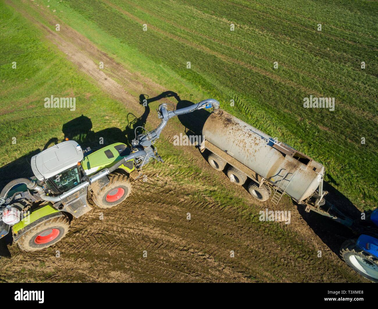 aerial view of a tractor with a modern fertilizer trailer and a second ...