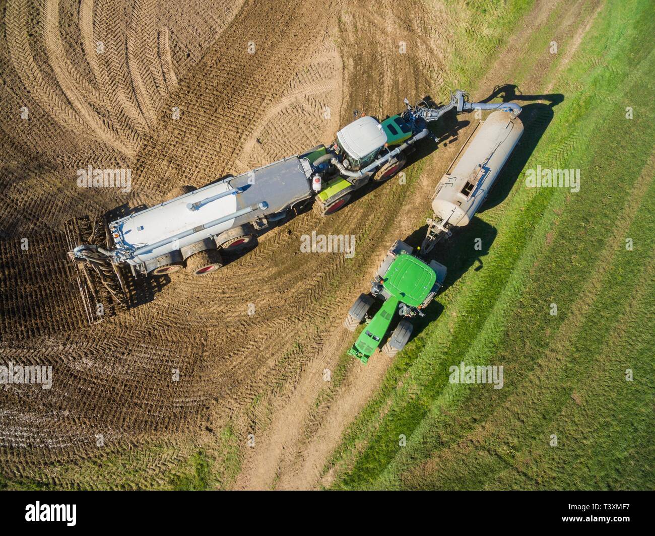 aerial view of a tractor with a modern fertilizer trailer and a second ...