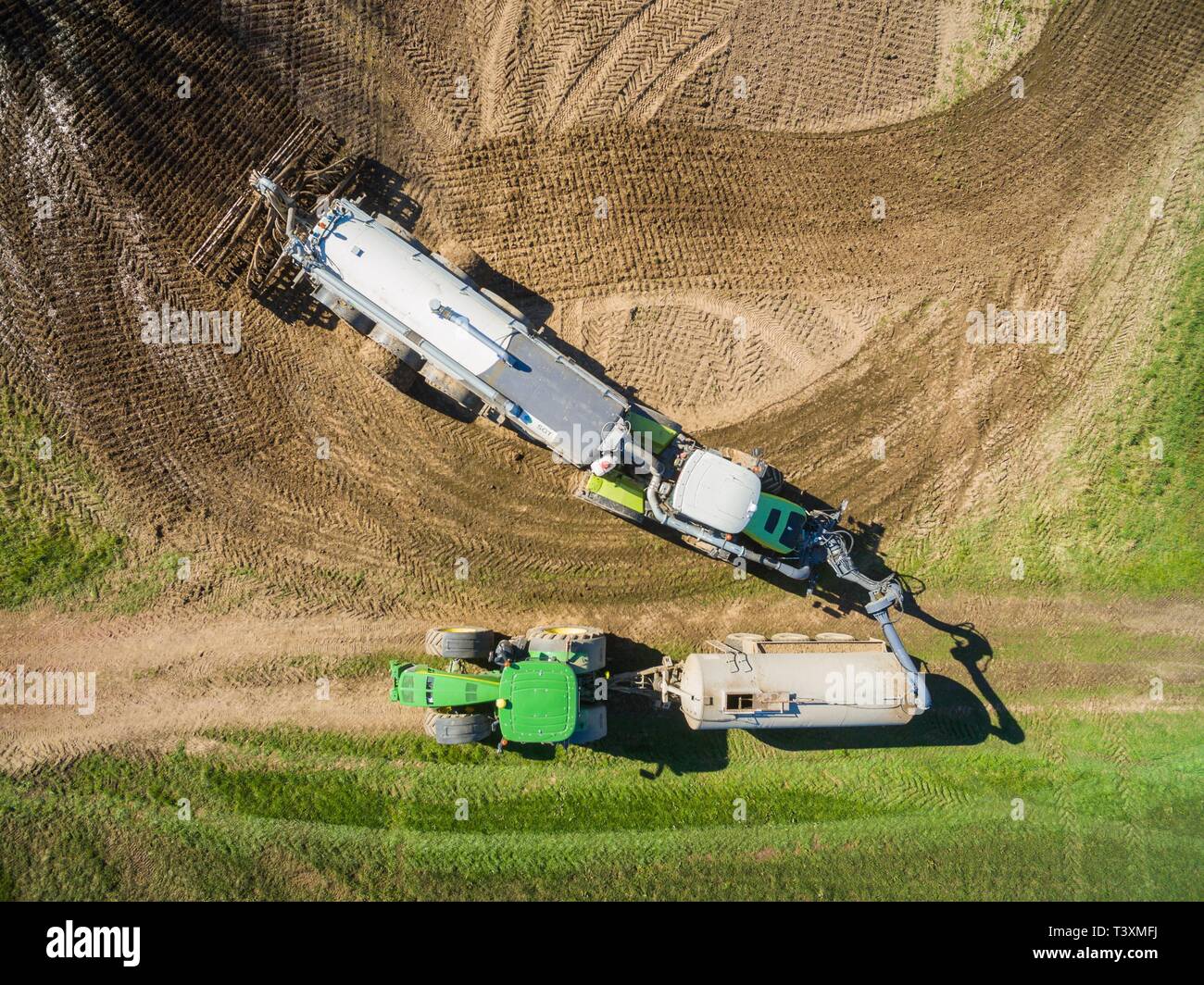 aerial view of a tractor with a modern fertilizer trailer and a second ...