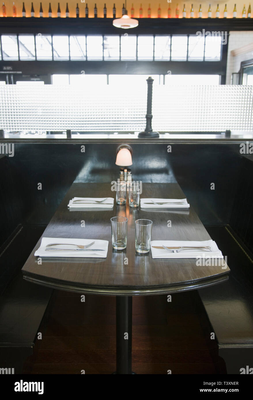 Place settings on empty booth table in restaurant Stock Photo - Alamy