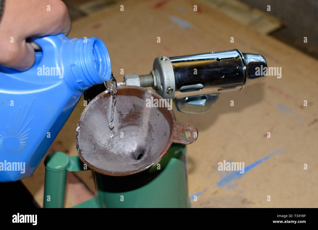 Pouring gasoline blowtorch through the funnel Stock Photo - Alamy