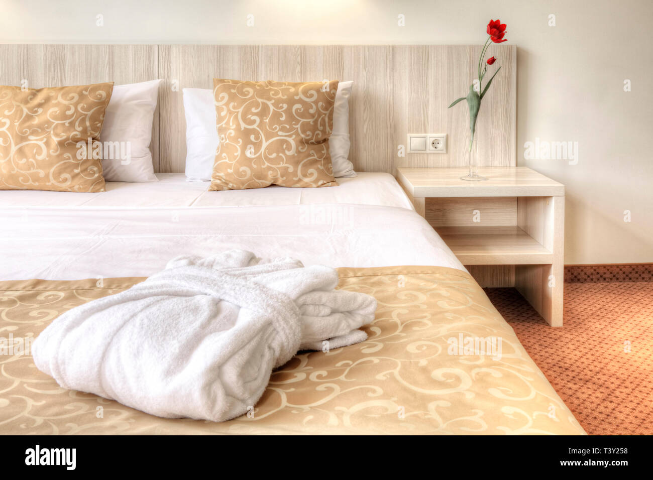 Folded robe on bed in hotel room Stock Photo - Alamy