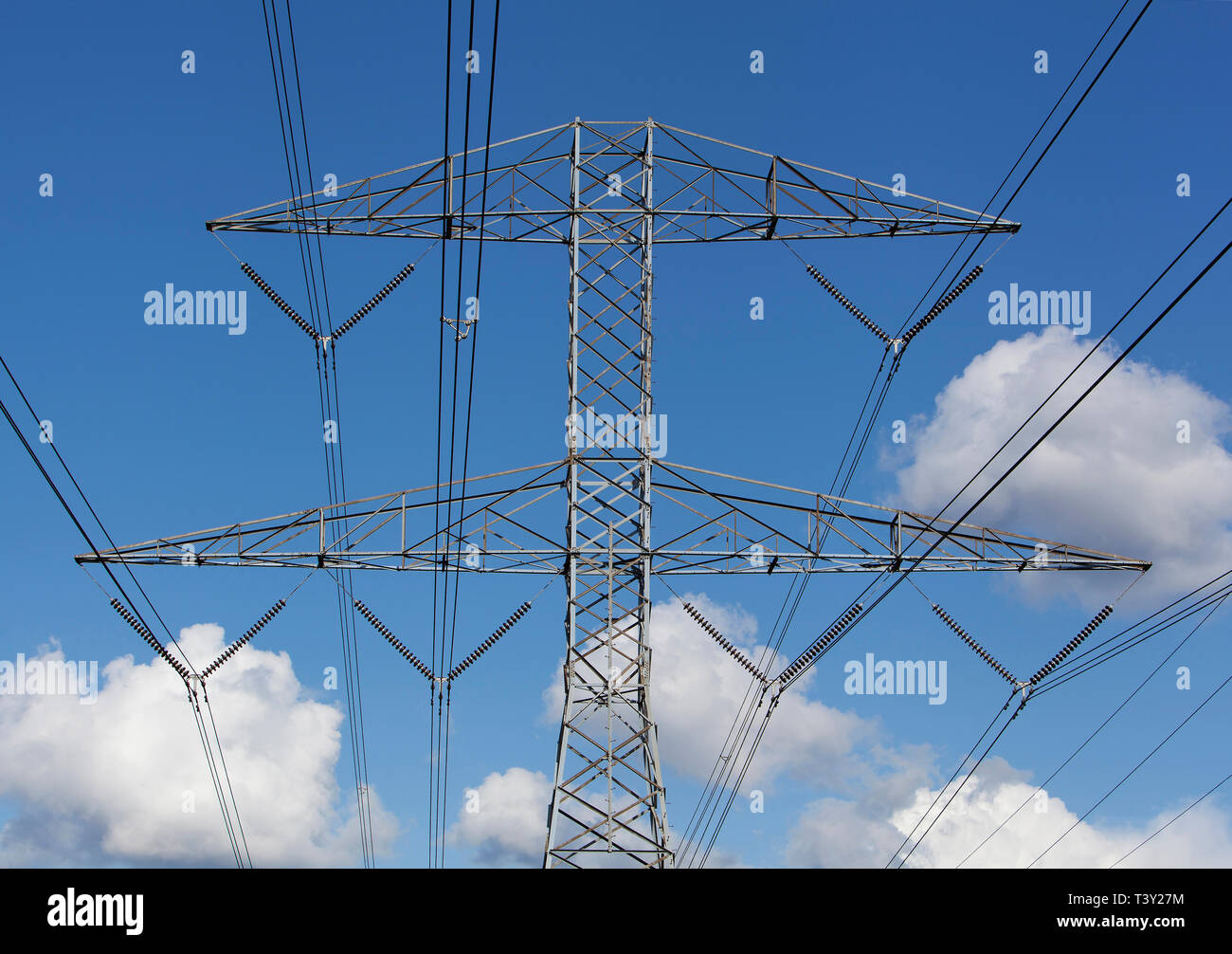 Power lines against blue sky Stock Photo - Alamy