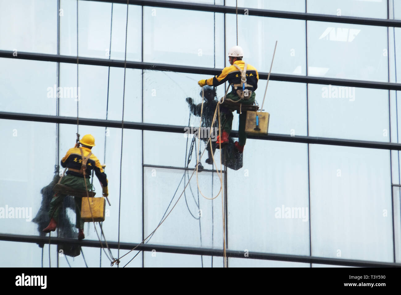 Workers clean the glass facade of a skyscraper in shenzhen, China Stock ...