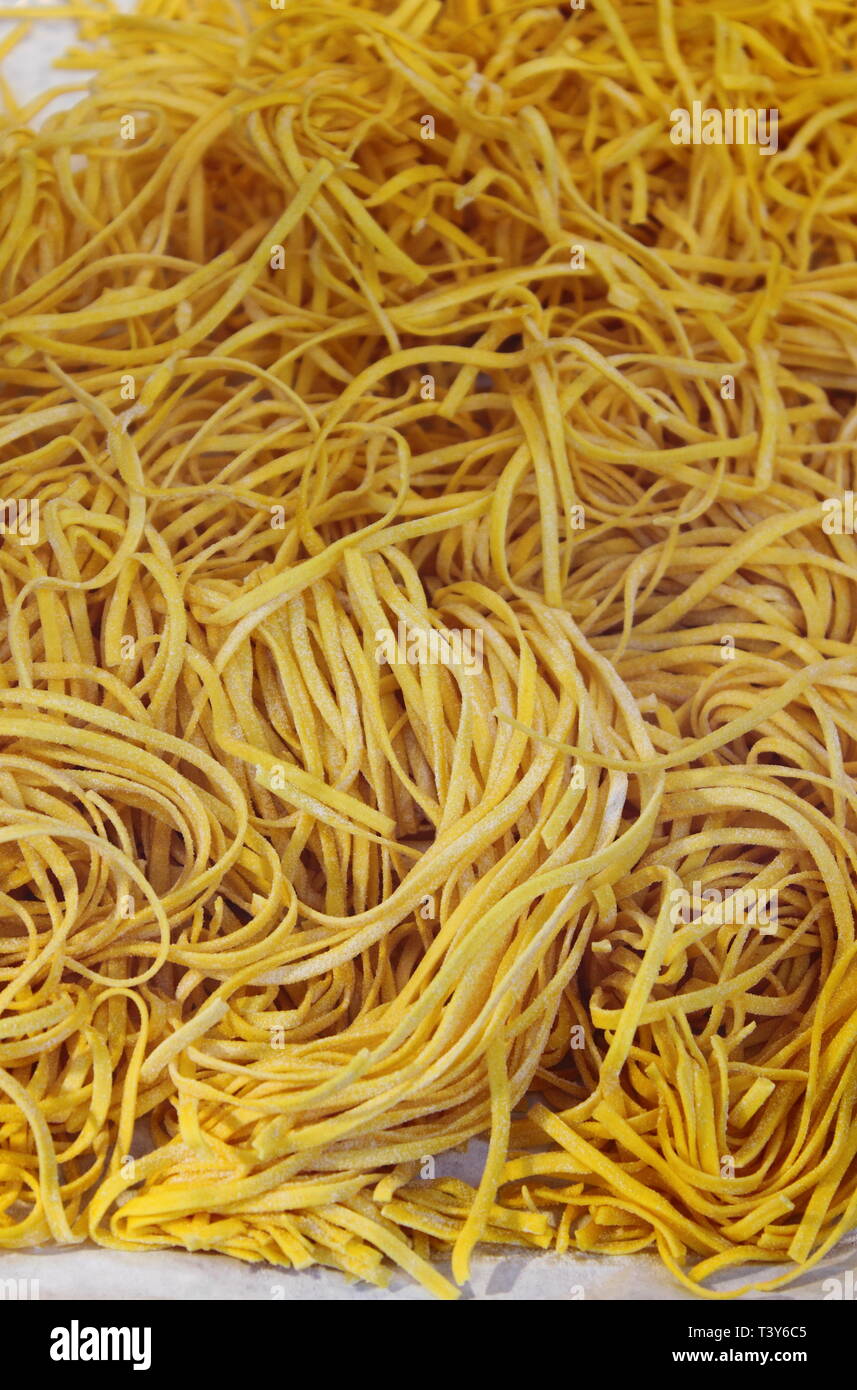 Raw italian tagliatelle pasta background Stock Photo - Alamy