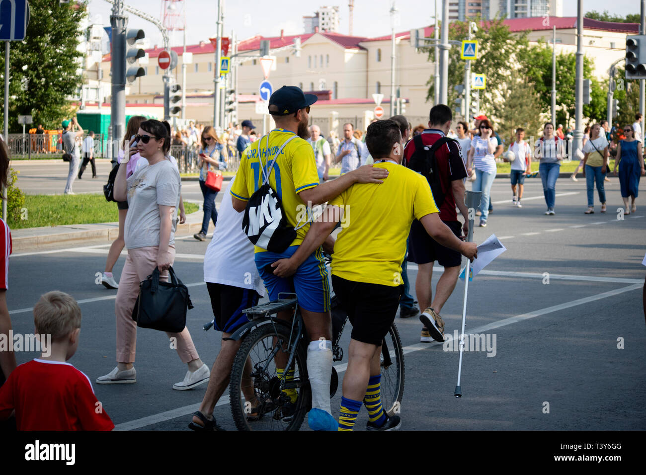 Swedish male football fan pushes another male fan on cycle with hand on ...