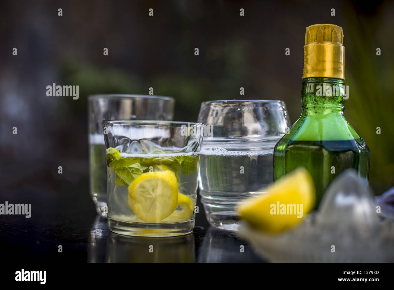 Mojito drink in a transparent glass on wooden surface with white rum ...