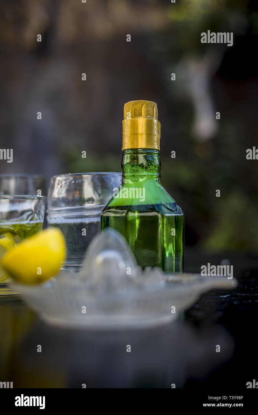 Mojito drink in a transparent glass on wooden surface with white rum ...