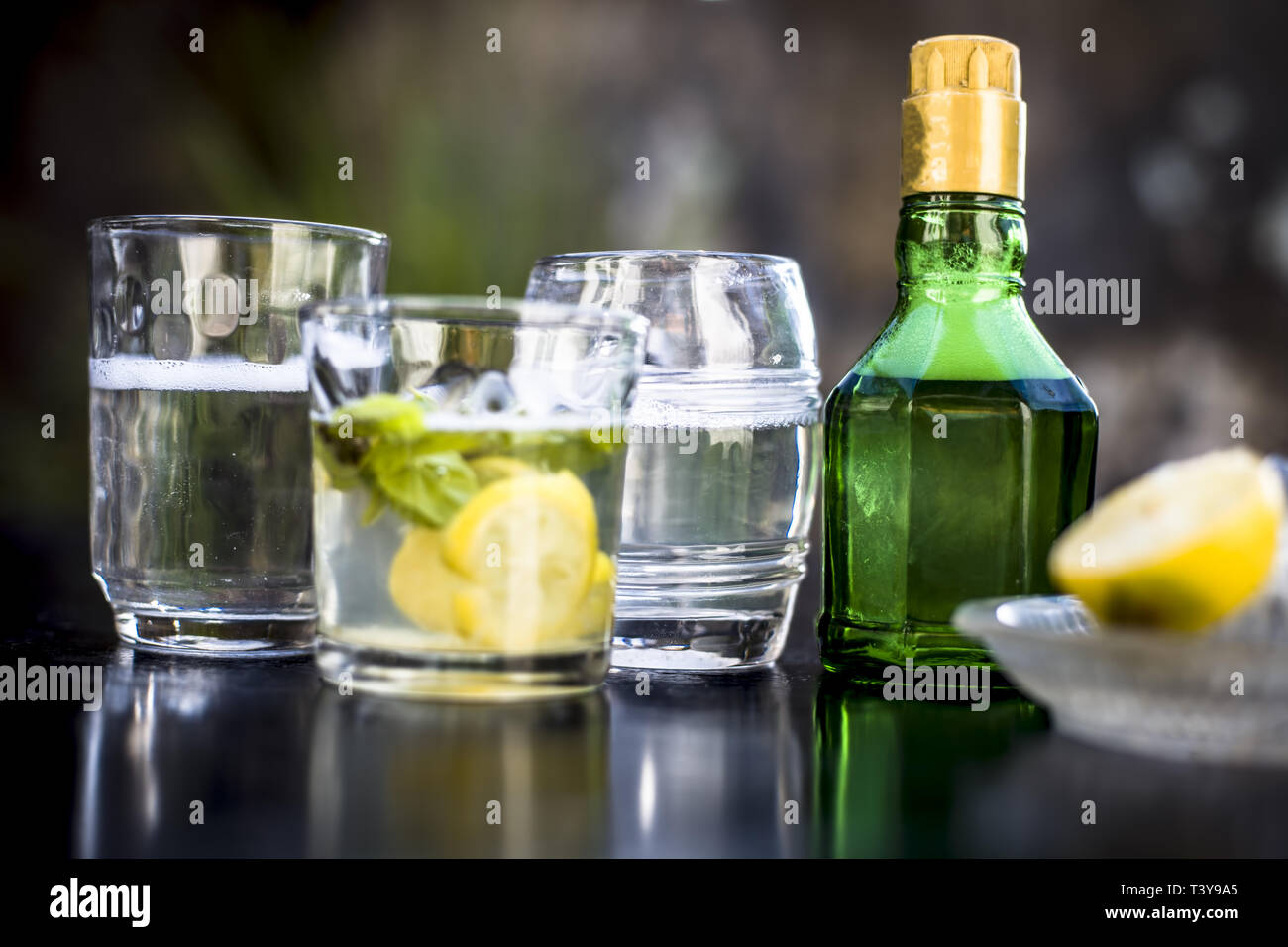 Mojito drink in a transparent glass on wooden surface with white rum ...