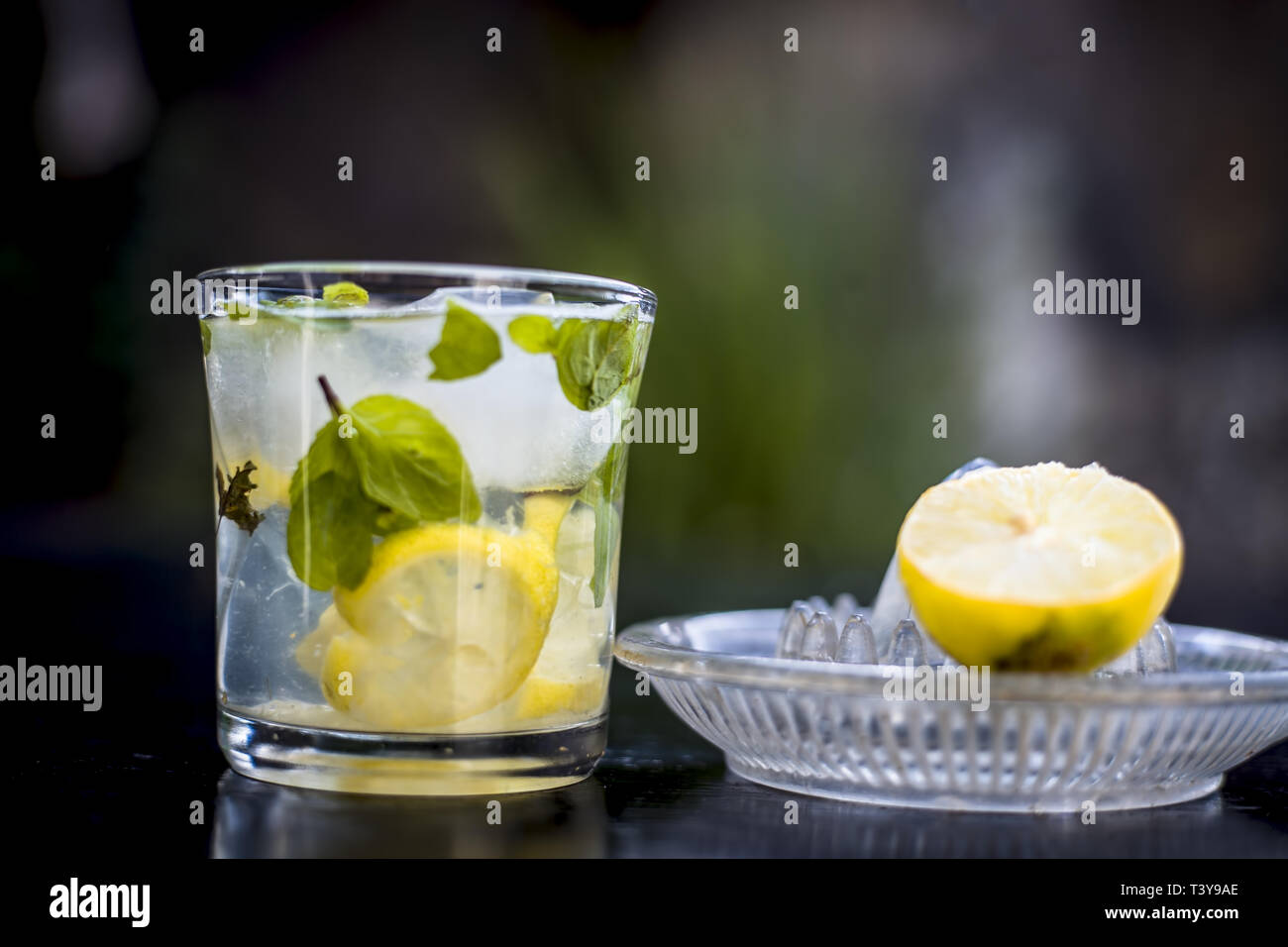 Mojito drink in a transparent glass on wooden surface with white rum ...