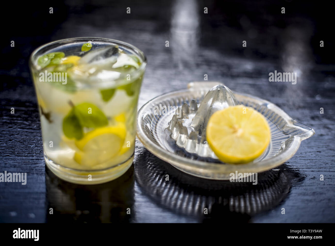 Mojito drink in a transparent glass on wooden surface with white rum ...