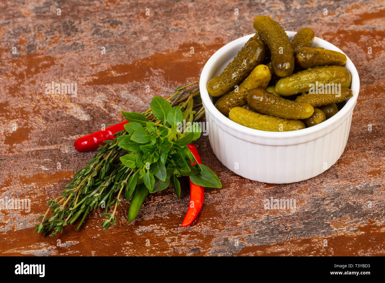 Pickled small cucumbers in the bowl served herbs Stock Photo - Alamy