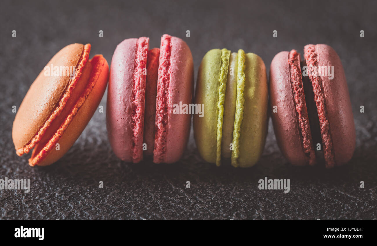Colorful macarons on the dark background Stock Photo - Alamy