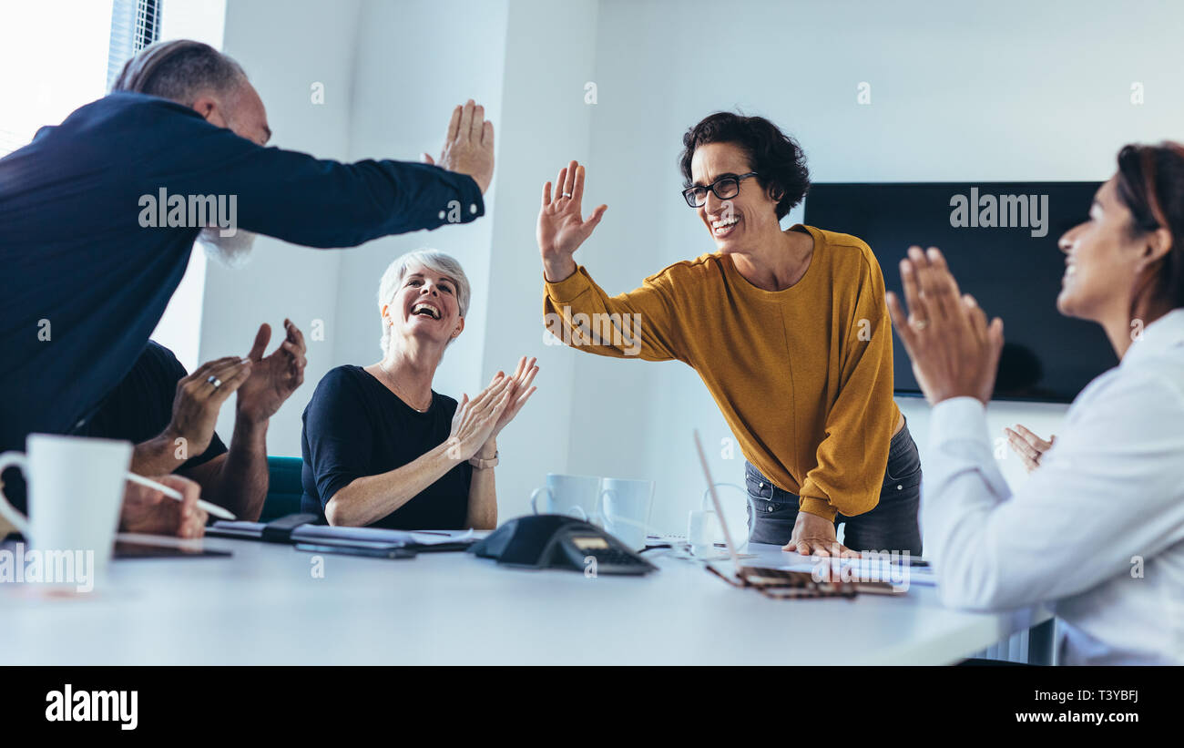 Business people giving each other high five and clapping. Business team celebrating success ...