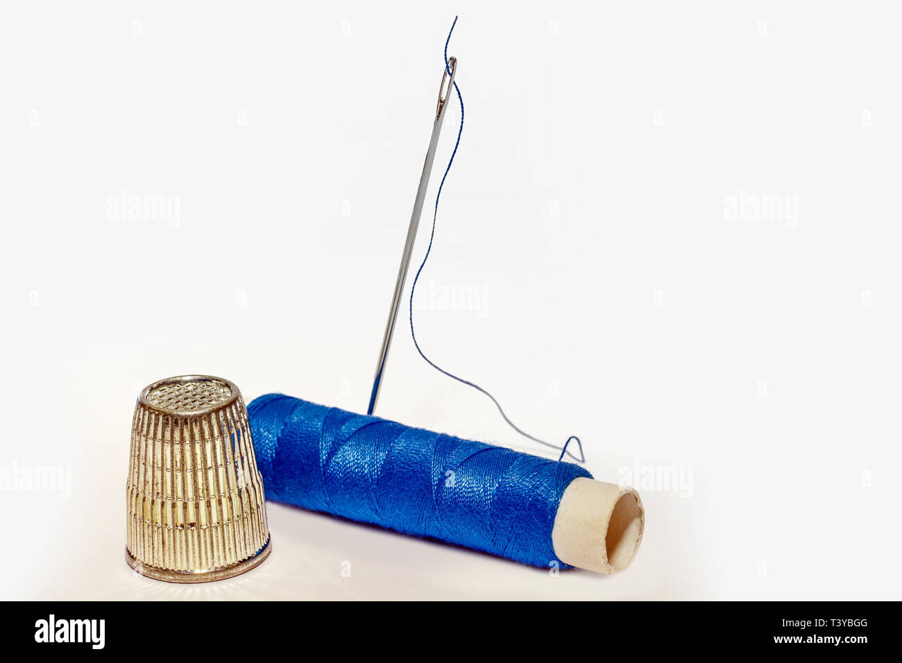 Needle, thread and thimble on a white background Stock Photo - Alamy