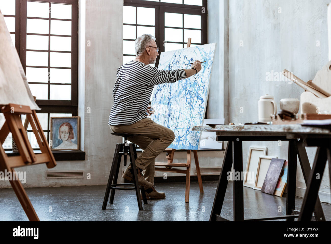 Painting on canvas. Talented bearded artist feeling inspired while ...