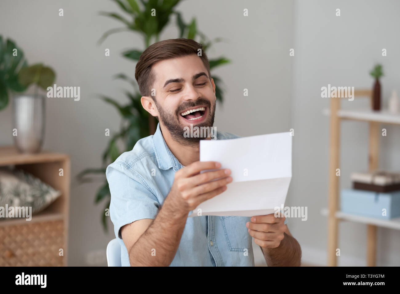 Happy laughing man holding paper notification, letter with good news ...