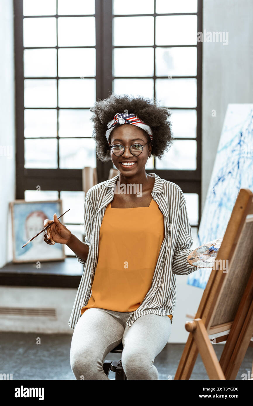 Young but promising. Young but promising artist sitting on chair near ...