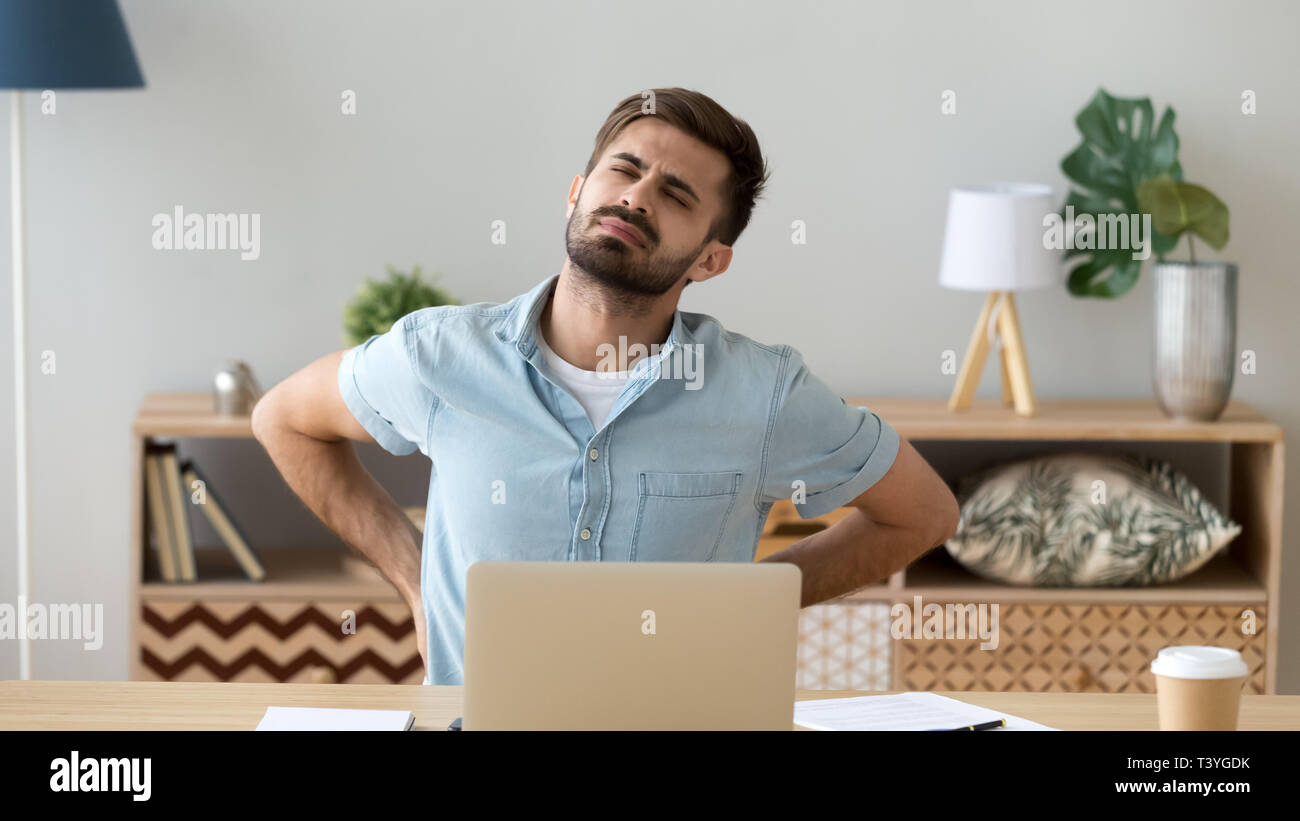 Tired man feeling backache after sedentary computer work Stock Photo ...