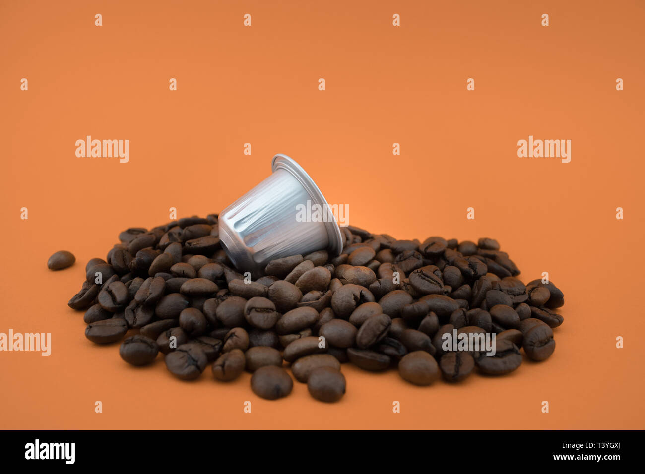 Espresso coffee capsule or coffee pod on coffee beans, orange ...