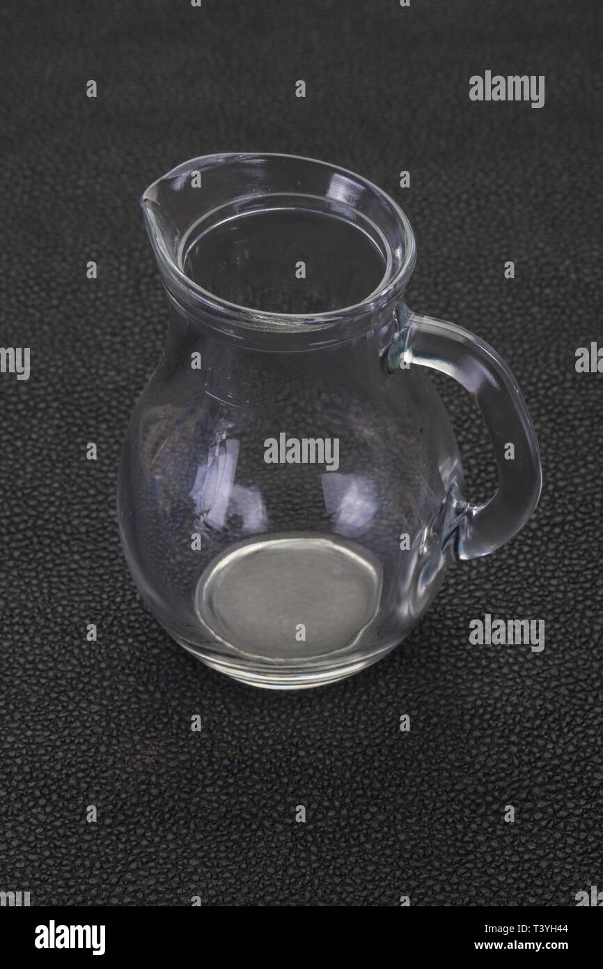 Empty glass jug over black background Stock Photo - Alamy