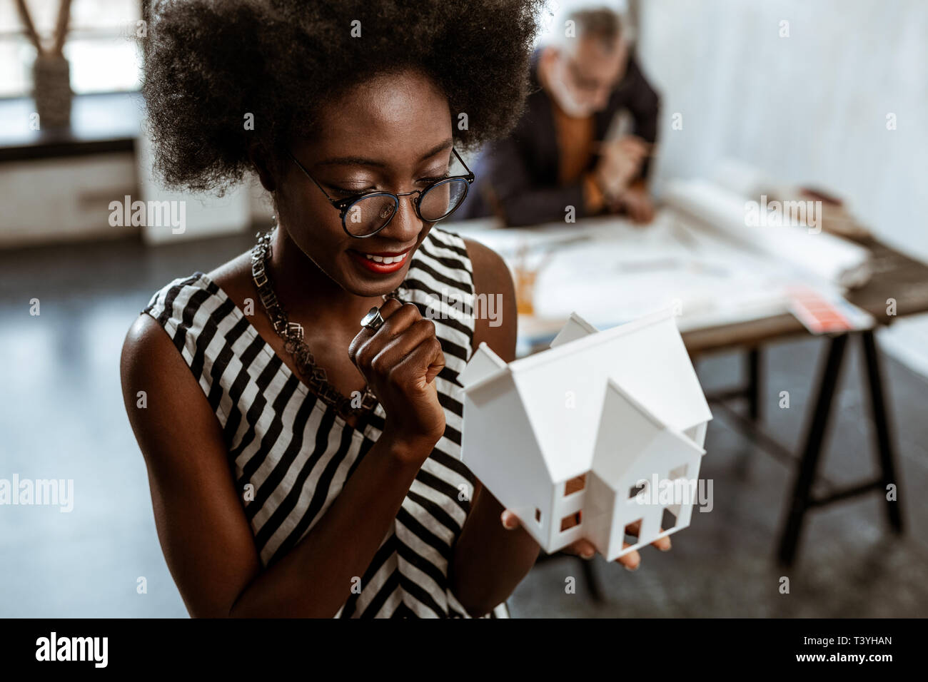 Looking at model. Stylish young interior designer wearing stylish ...