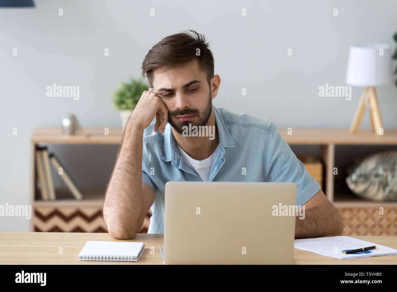 Tired student or employee working with laptop, doing boring job Stock ...