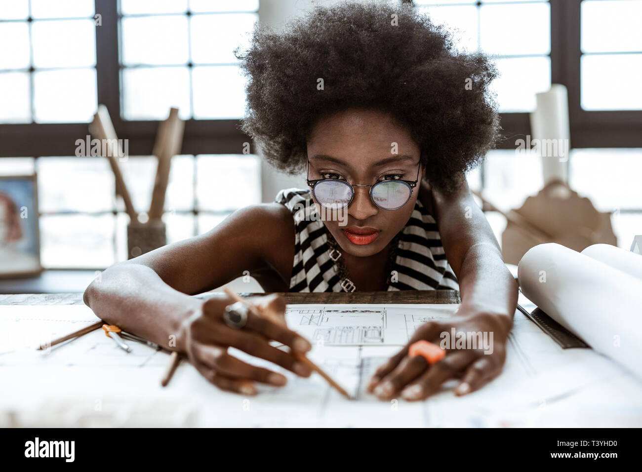 Pencil and ruler Dark-eyed young interior designer using pencil and ...