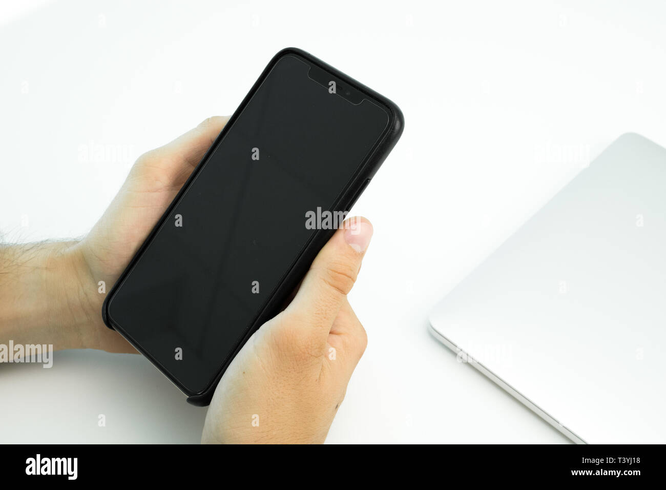 Business person using his smartphone on a white table. Modern workplace ...