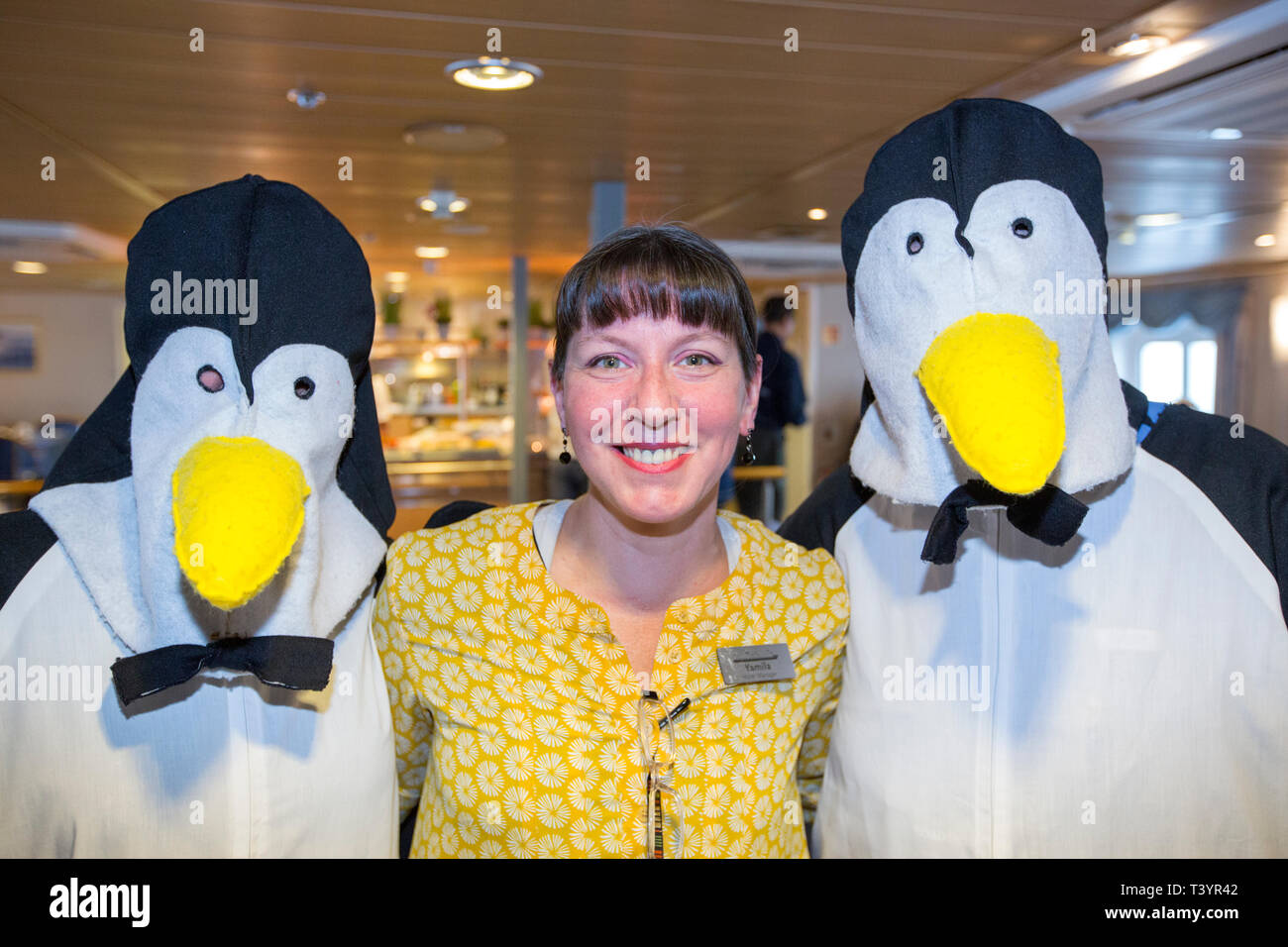 A woman and two people dressed up as penguins on an Antarctic cruise ...