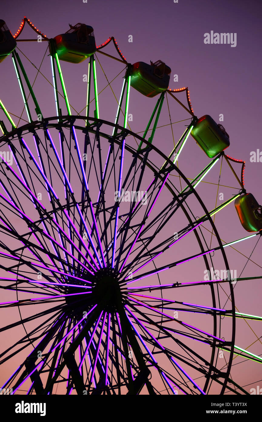 Neon Ferris Wheel ride at amusement park at night Stock Photo - Alamy