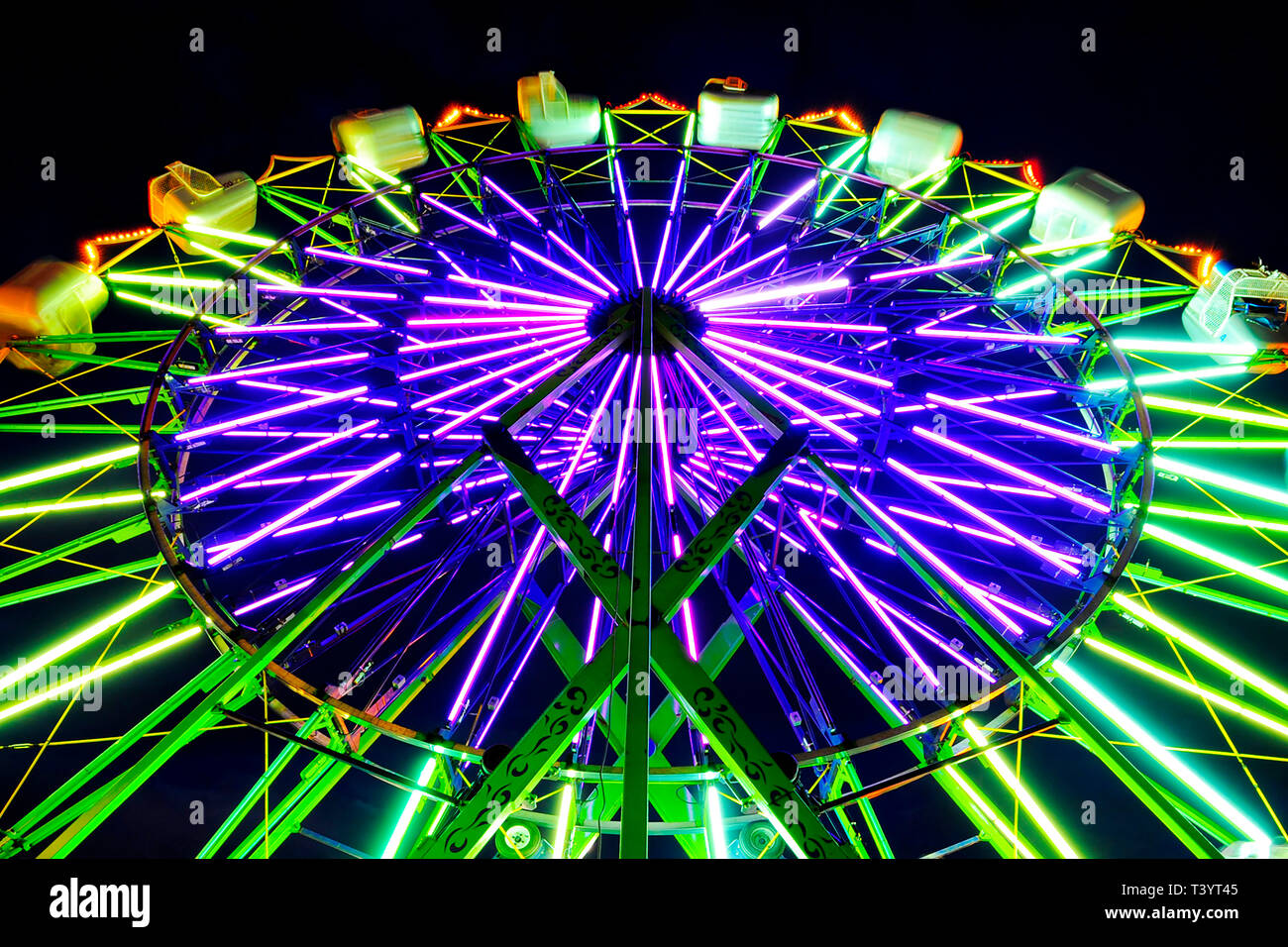 Neon Ferris Wheel ride at amusement park at night Stock Photo - Alamy