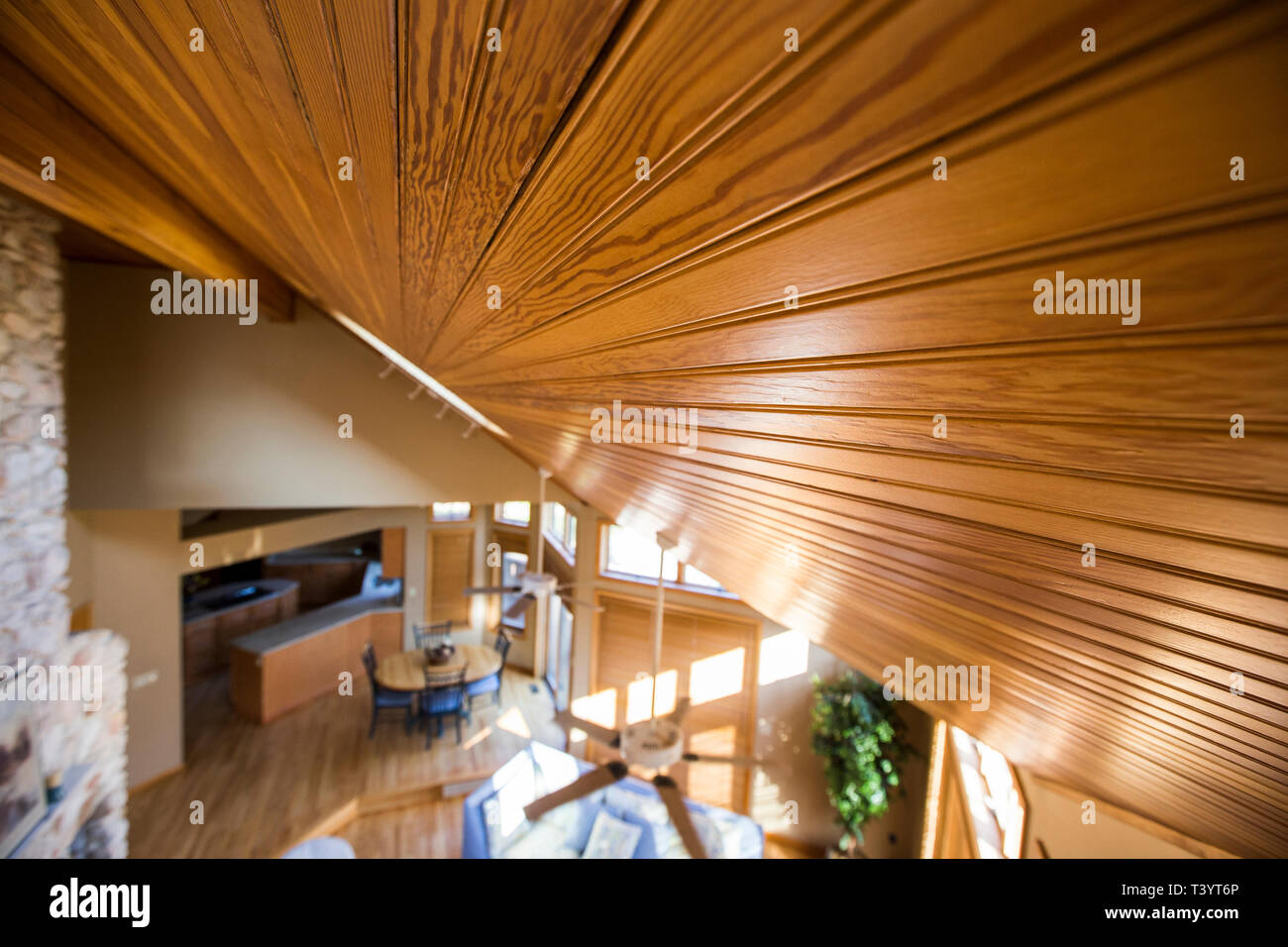 Slanted wood ceiling over living room and dining room Stock Photo - Alamy
