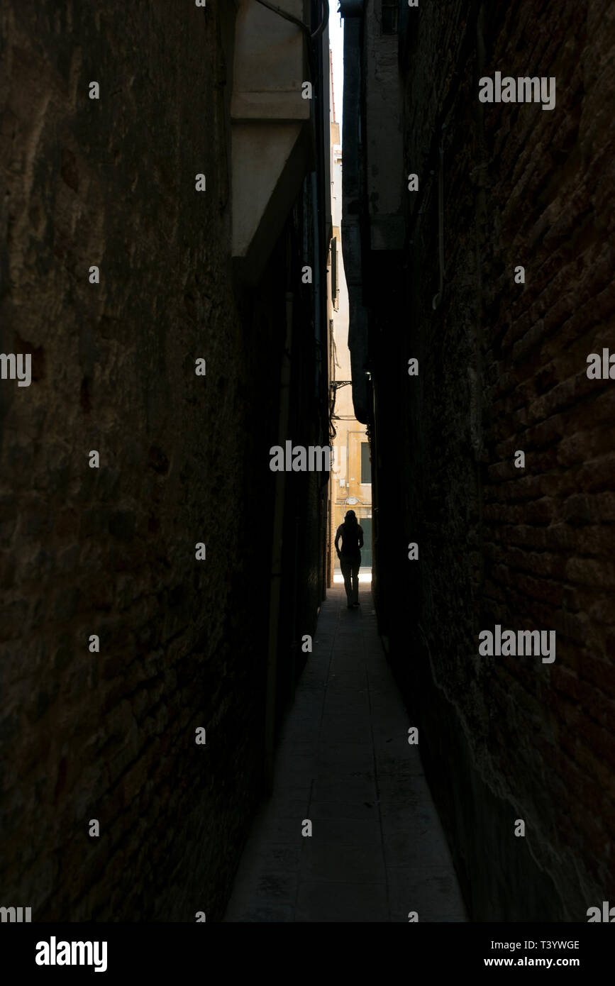 An unusual narrow street between houses in Venice. Italy Stock Photo ...
