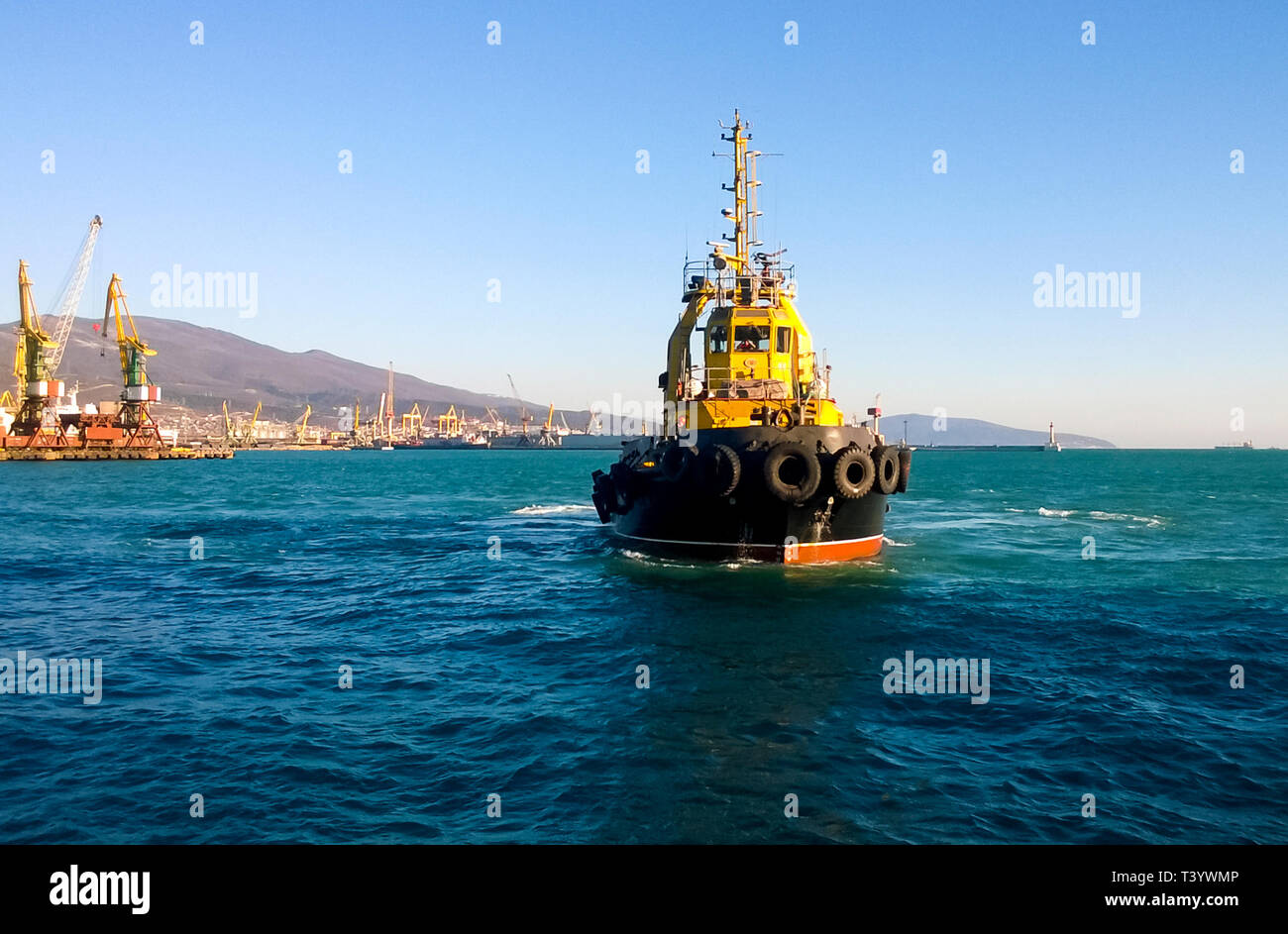 A small service ship in a cargo industrial port. A ship in the sea ...