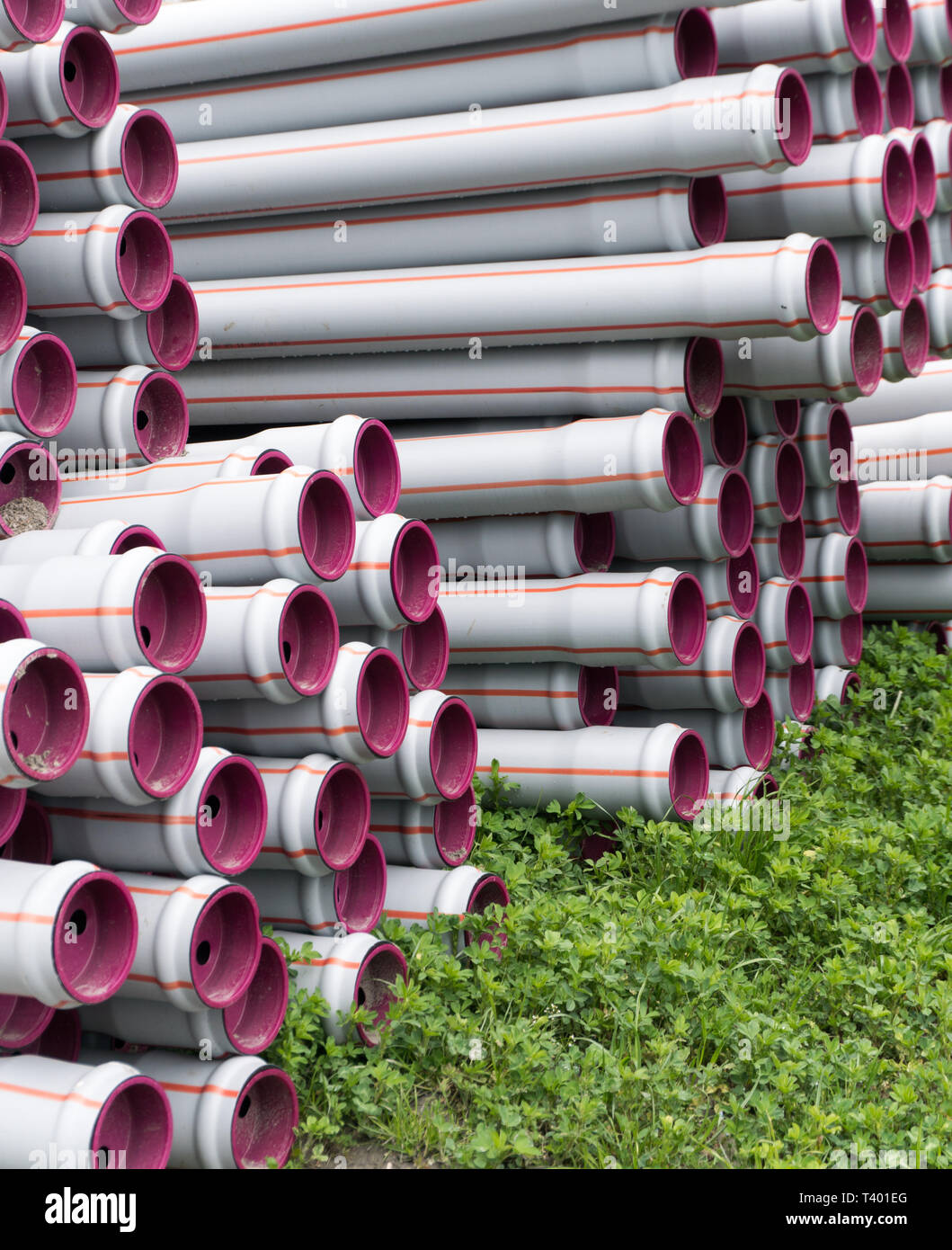 many stacked long plastic pipe tubes ready for building a water supply ...